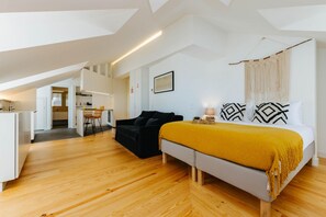 Um quarto moderno estilo loft com uma cama grande, um sofá e uma área de refeições.