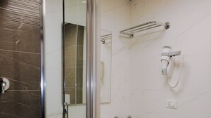 Uma casa de banho moderna com chuveiro de vidro, uma pia branca e um bidé.