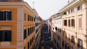 Rua estreita ladeada por edifícios amarelos, com uma placa indicando 'HOTELS' à direita.