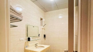 Casa de banho moderna com sanita, lavatório e chuveiro.