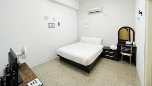 Quarto com cama, escrivaninha, cadeira, espelho e ar condicionado na parede.