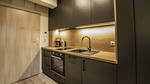 Uma cozinha moderna com bancada de madeira, eletrodomésticos de aço inoxidável e uma pia embutida.