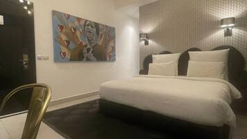 Quarto moderno com cama grande, um quadro na parede e um candelabro.
