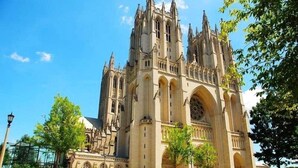 Uma catedral grande e histórica, com múltiplas torres e um arco central imponente.