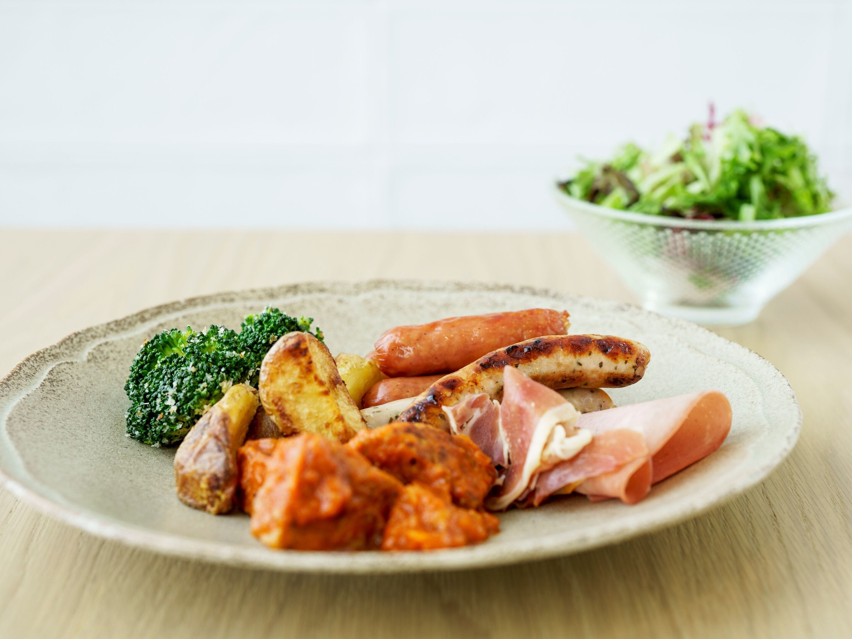 Um prato com carnes variadas, legumes e uma salada.