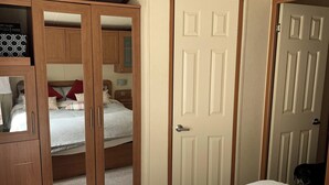 Um quarto com uma cama, um guarda-roupa e uma porta.