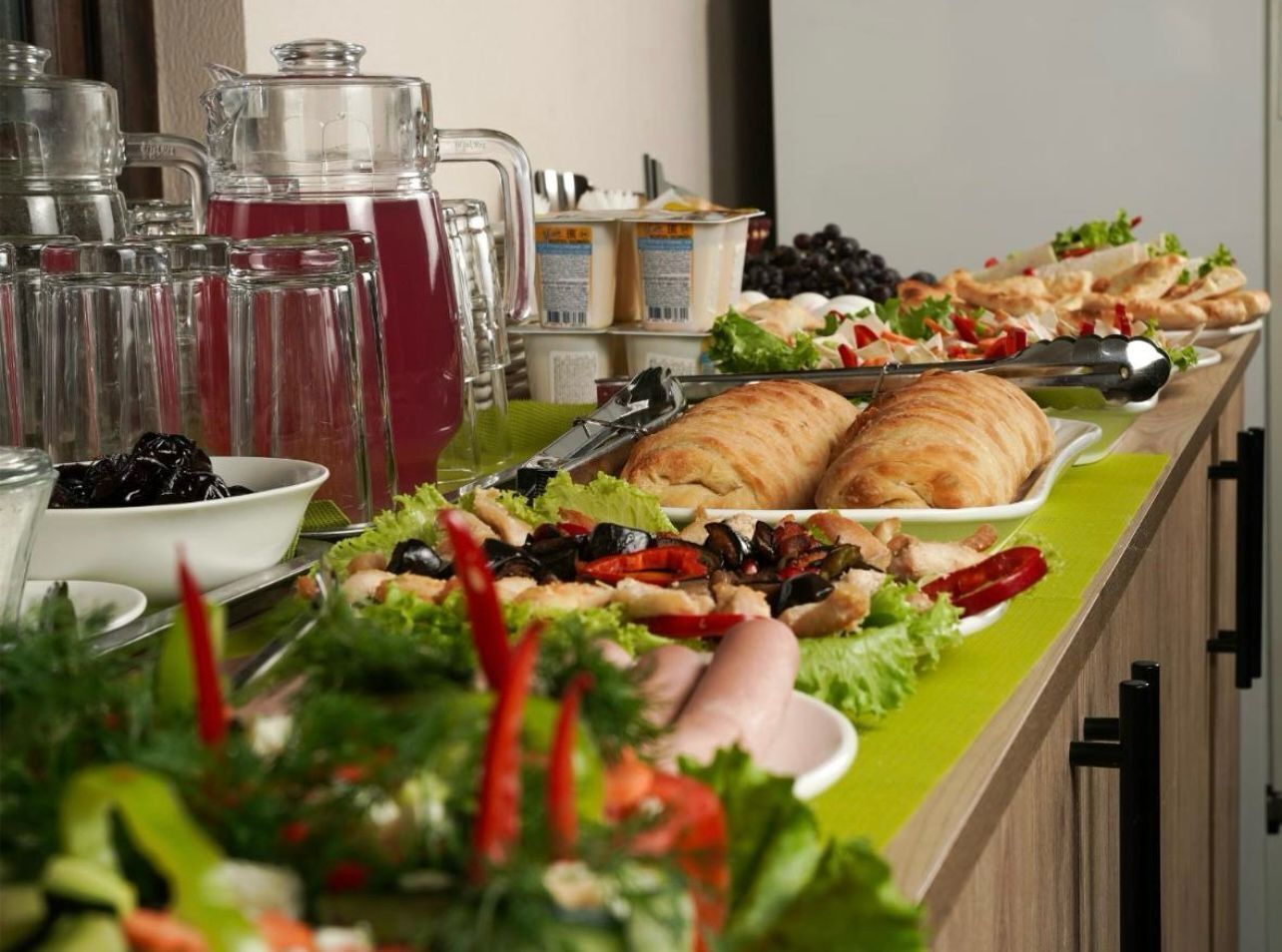 Buffet com diversas opções de comida, incluindo croissants, saladas e uma seleção de bebidas.