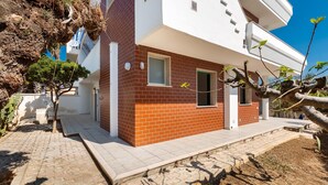 Um edifício moderno de dois andares com fachada de tijolo e níveis superiores brancos.