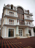 Um hotel com vários andares e estilo arquitetônico clássico, com varandas, janelas amplas e uma entrada imponente.