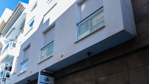 Um edifício moderno com uma placa indicando ser um prédio de apartamentos para turistas.