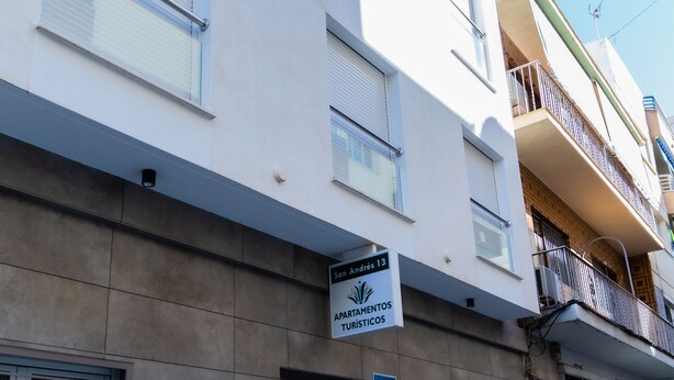 Um edifício com placa indicando 'Apartamentos Turísticos' e um sinal azul da AT.