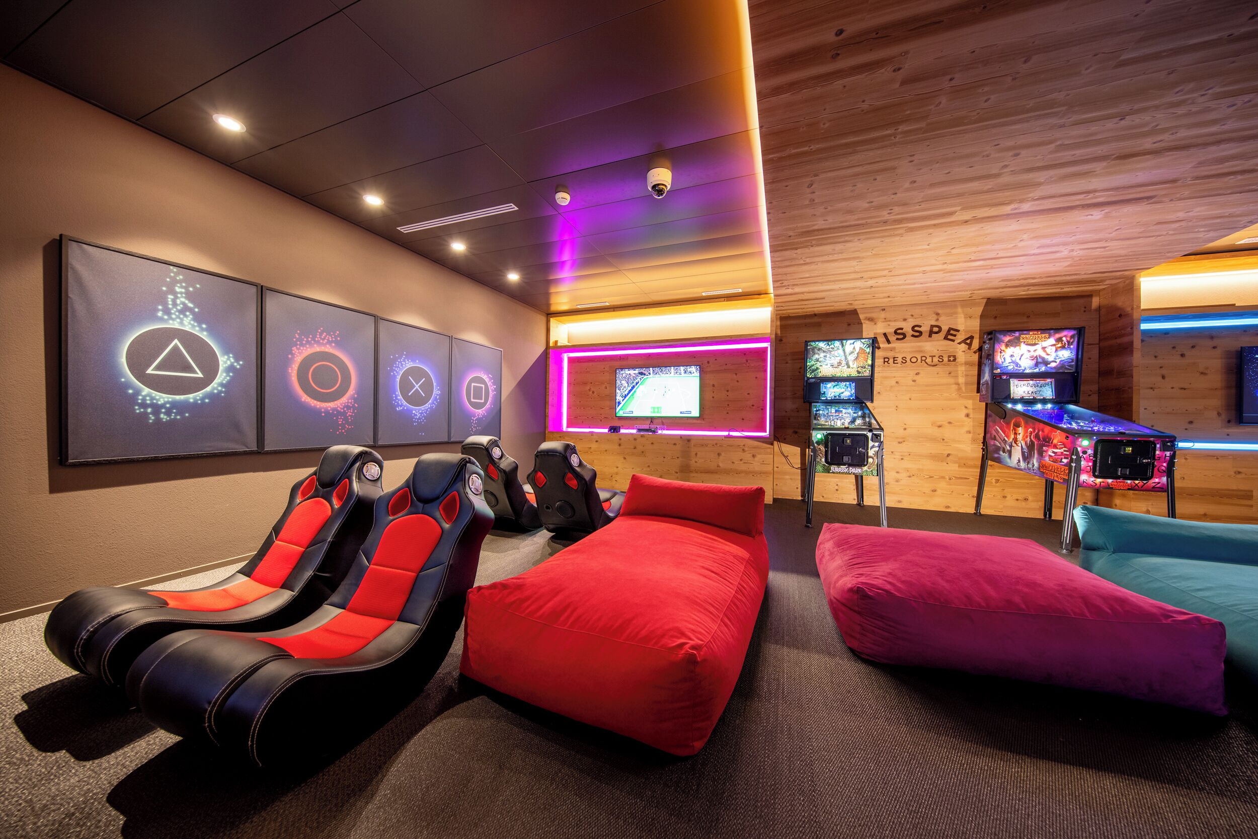 Um quarto com cadeiras de massagem, uma televisão e um aviso que diz 'ASSPEAK RESORTS'.