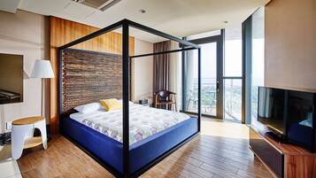 Quarto moderno com cama de dossel, televisão e grande janela com vista para a cidade.