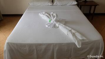 Cama bem arrumada com arranjo de toalha em formato de cisne.