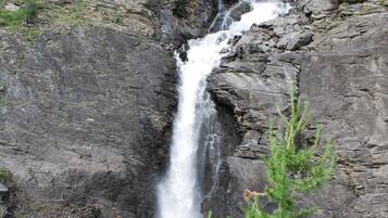 Uma cascata desce por um penhasco rochoso.