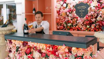 Uma área de bar com um arranjo floral e uma placa indicando Bollinger 1829.