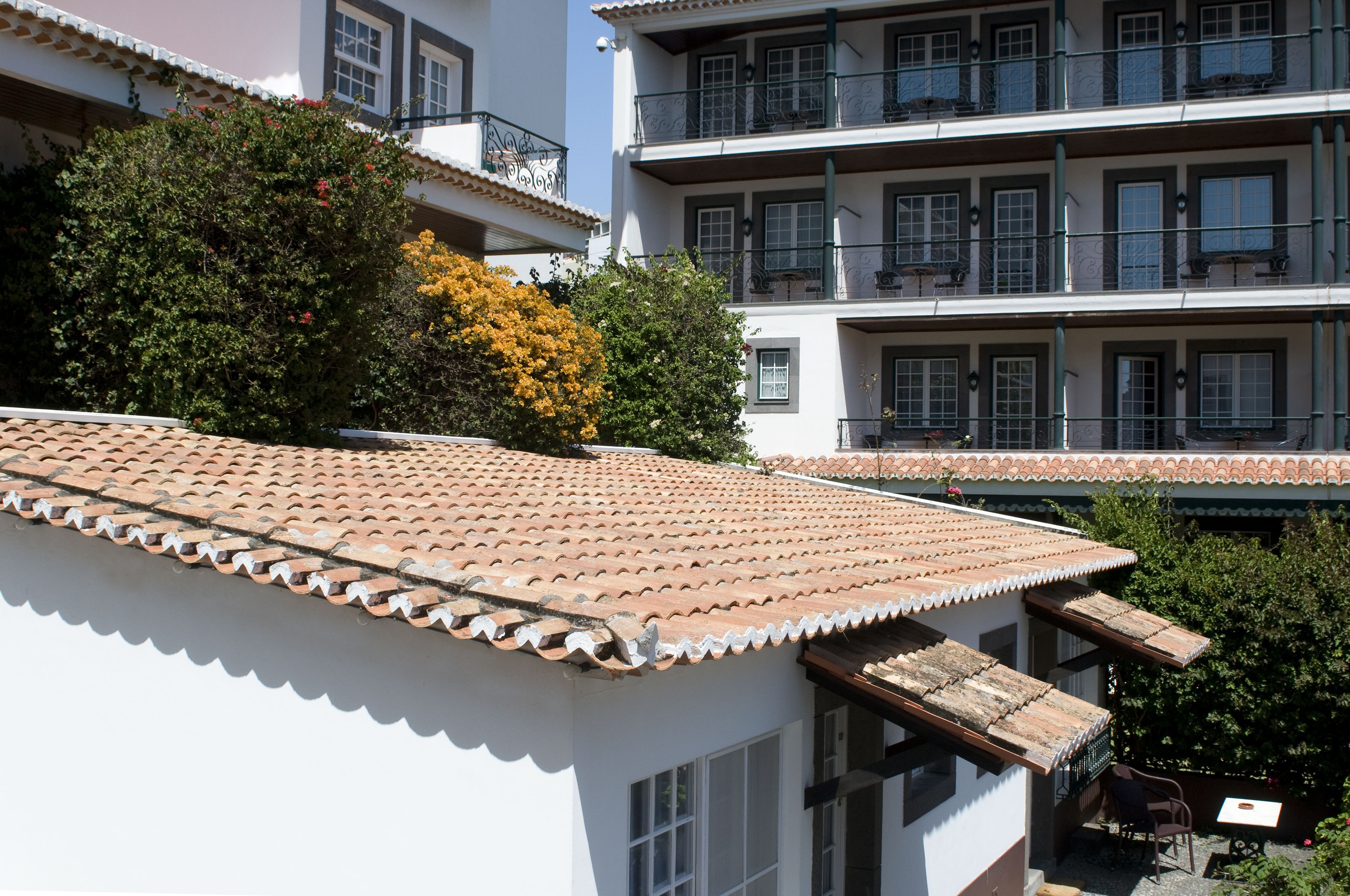 Um edifício de vários andares com telhado de telhas, varandas e janelas.