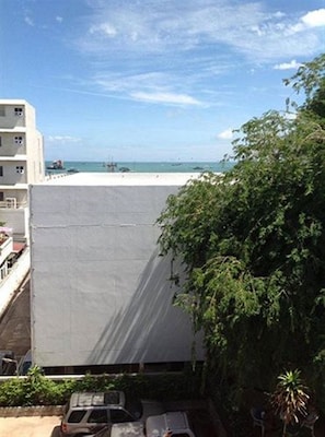 Um edifício com telhado plano, área coberta e vista para o mar.