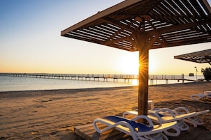 Praia particular, espreguiçadeiras, guarda-sóis, toalhas de praia