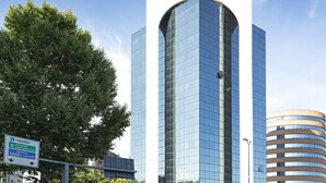 Um edifício moderno de hotel com fachada de vidro curva e uma placa indicando que se trata de um hotel B&B.