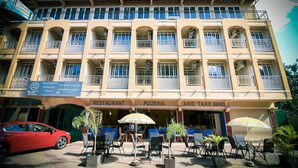 Um edifício com vários andares, com restaurante, pizzaria e serviço de refeições para levar no andar térreo.
