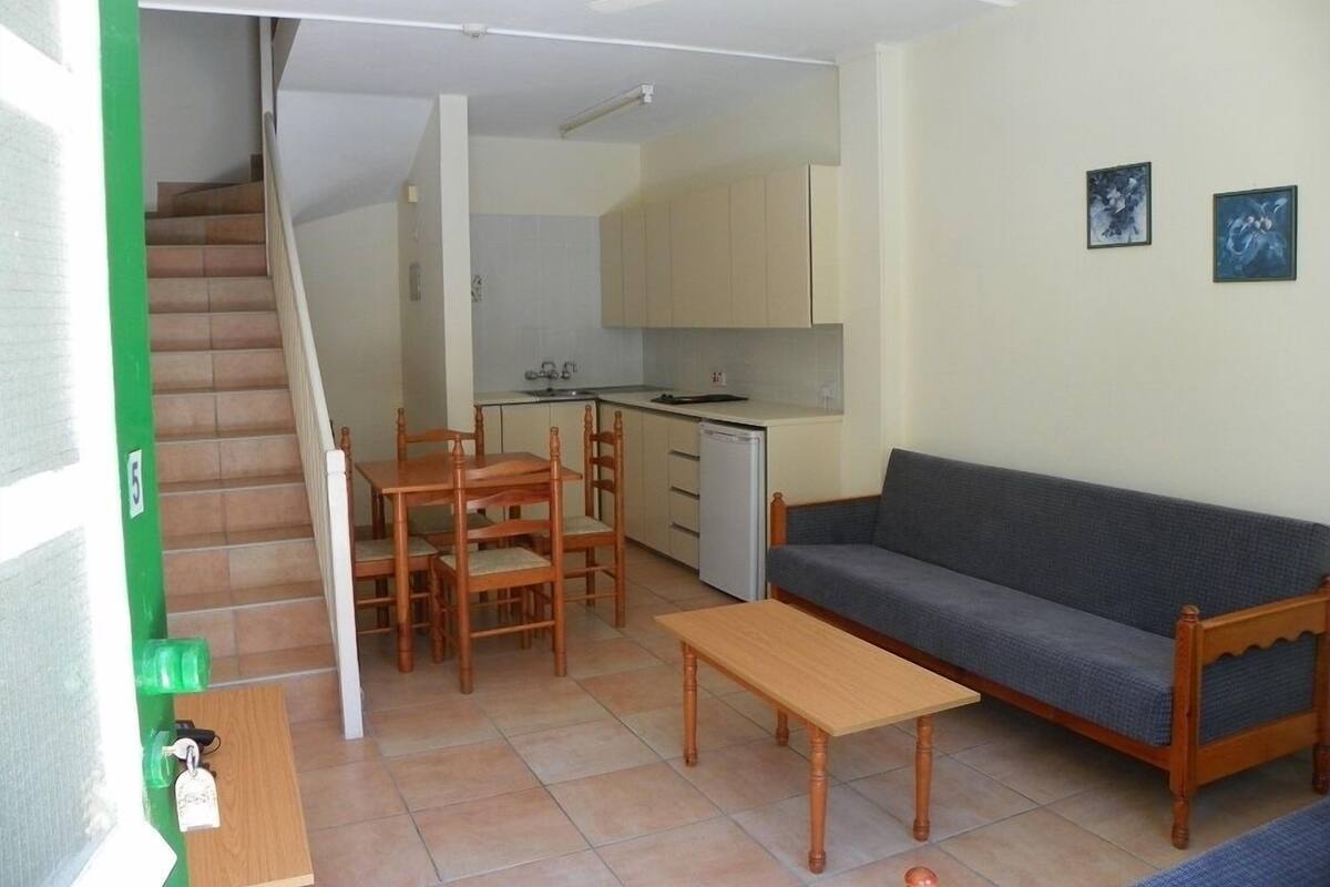Um espaço compacto com área de refeições, cozinha compacta e sofá.
