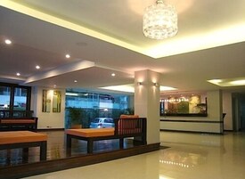 Um lobby moderno com parede de vidro, área de estar e um candelabro.