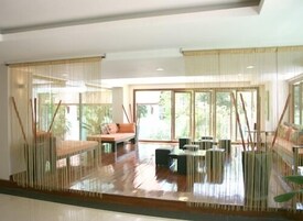 Um quarto amplo com uma janela grande, um sofá, uma mesa de centro e um espaço para refeições.
