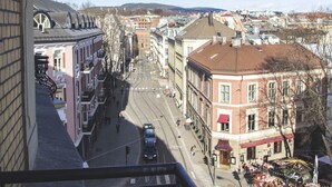 Varanda com vista para uma rua da cidade, edifícios e céu claro.
