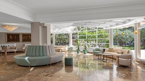 Um hall amplo com área de estar em curva, grandes janelas e um candelabro.