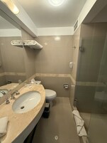 Uma casa de banho com lavatório, sanita e chuveiro.