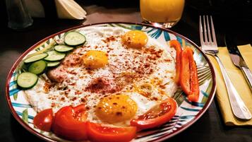 Um prato de comida com ovos, tomates, pepinos e pimentões.