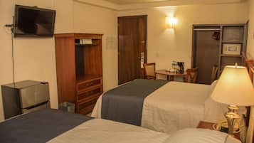 Quarto de hotel com duas camas, uma escrivaninha, uma cadeira, uma televisão e um micro-ondas.