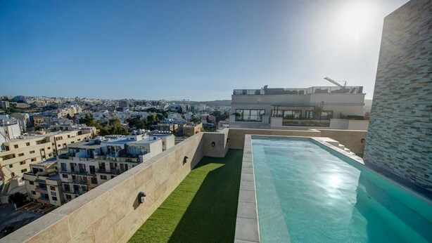 Piscina no terraço com vista para a paisagem urbana.