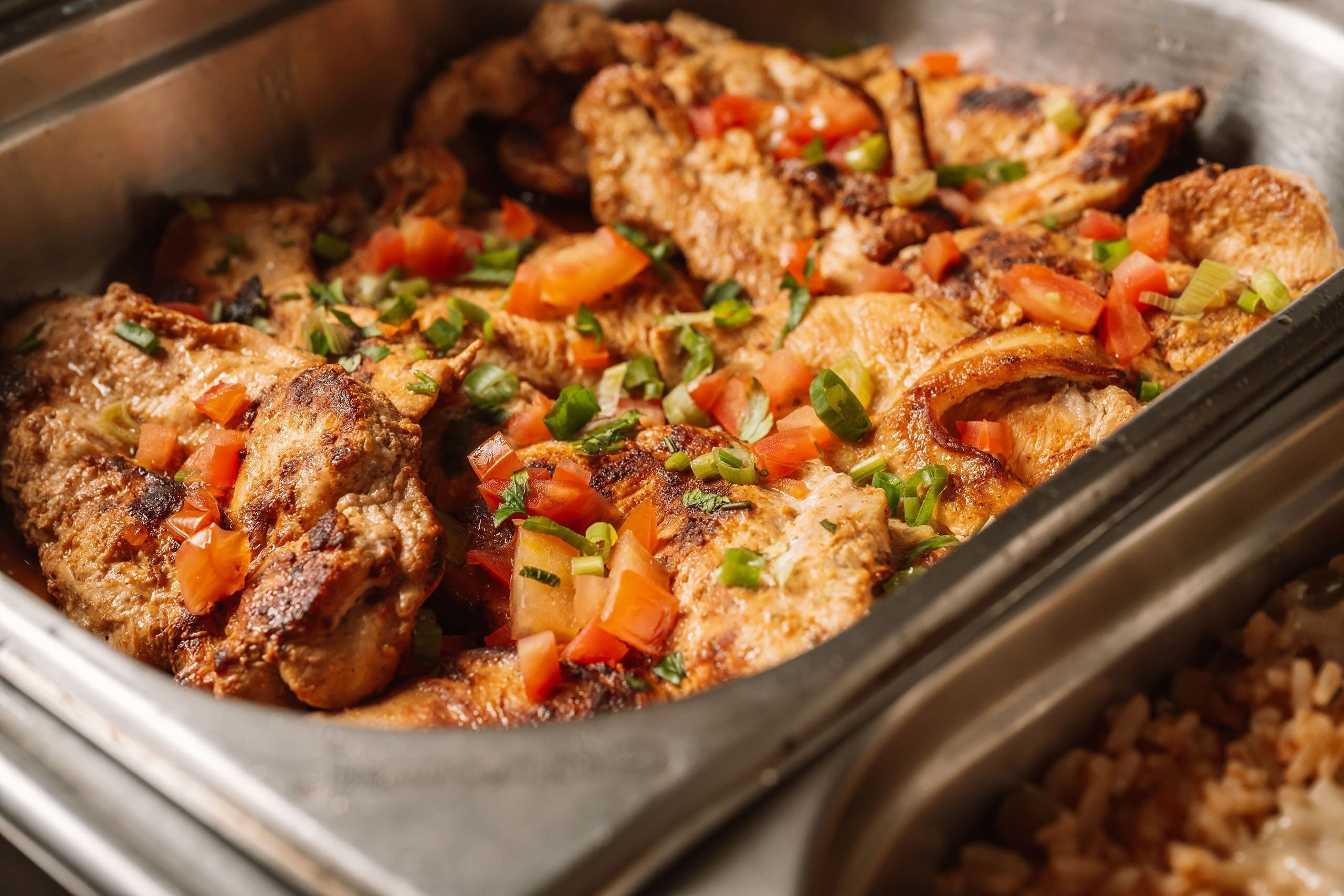 Uma bandeja com frango cozido e legumes.