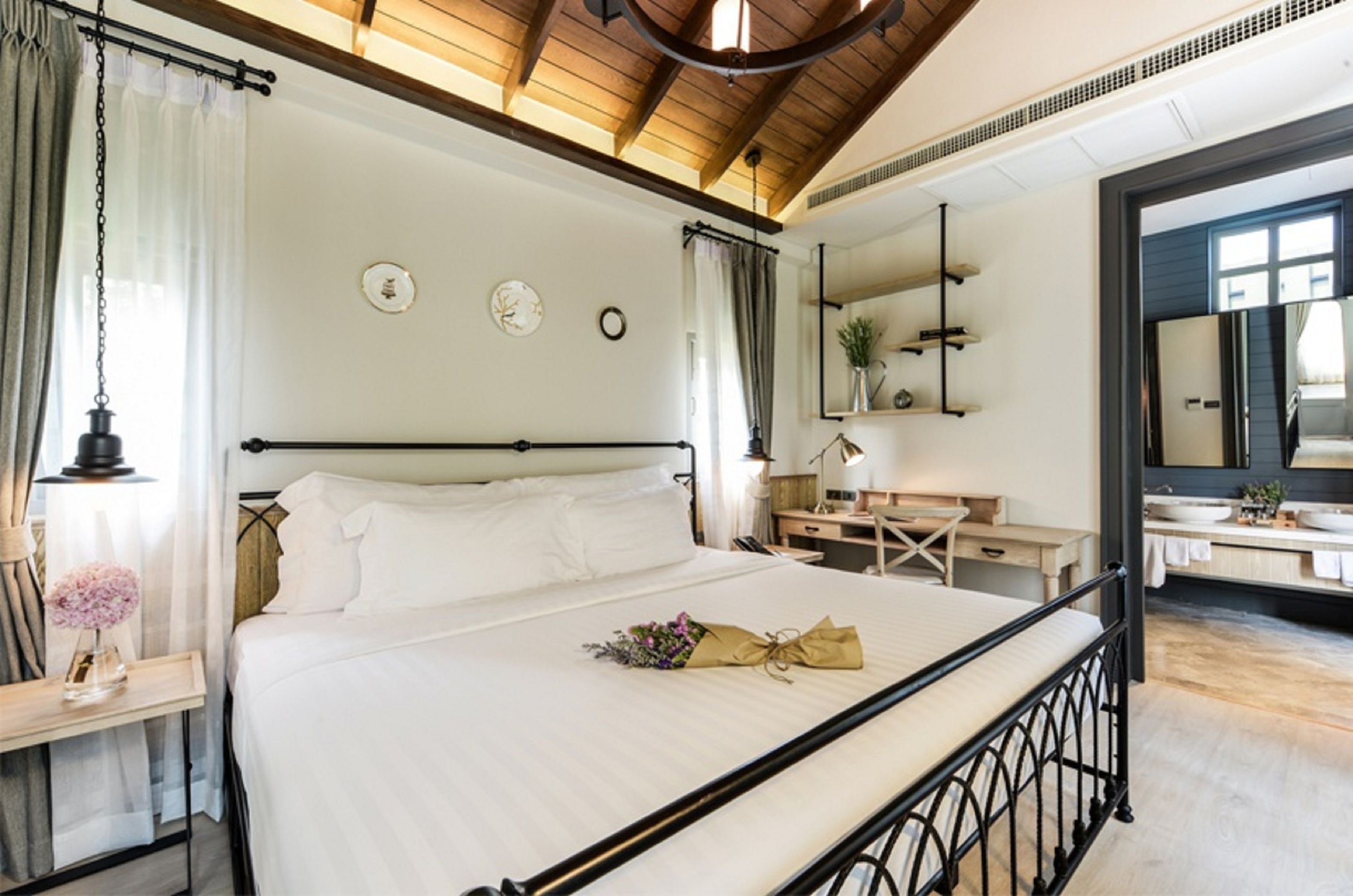 Um quarto com cama, mesa de cabeceira e espelho.
