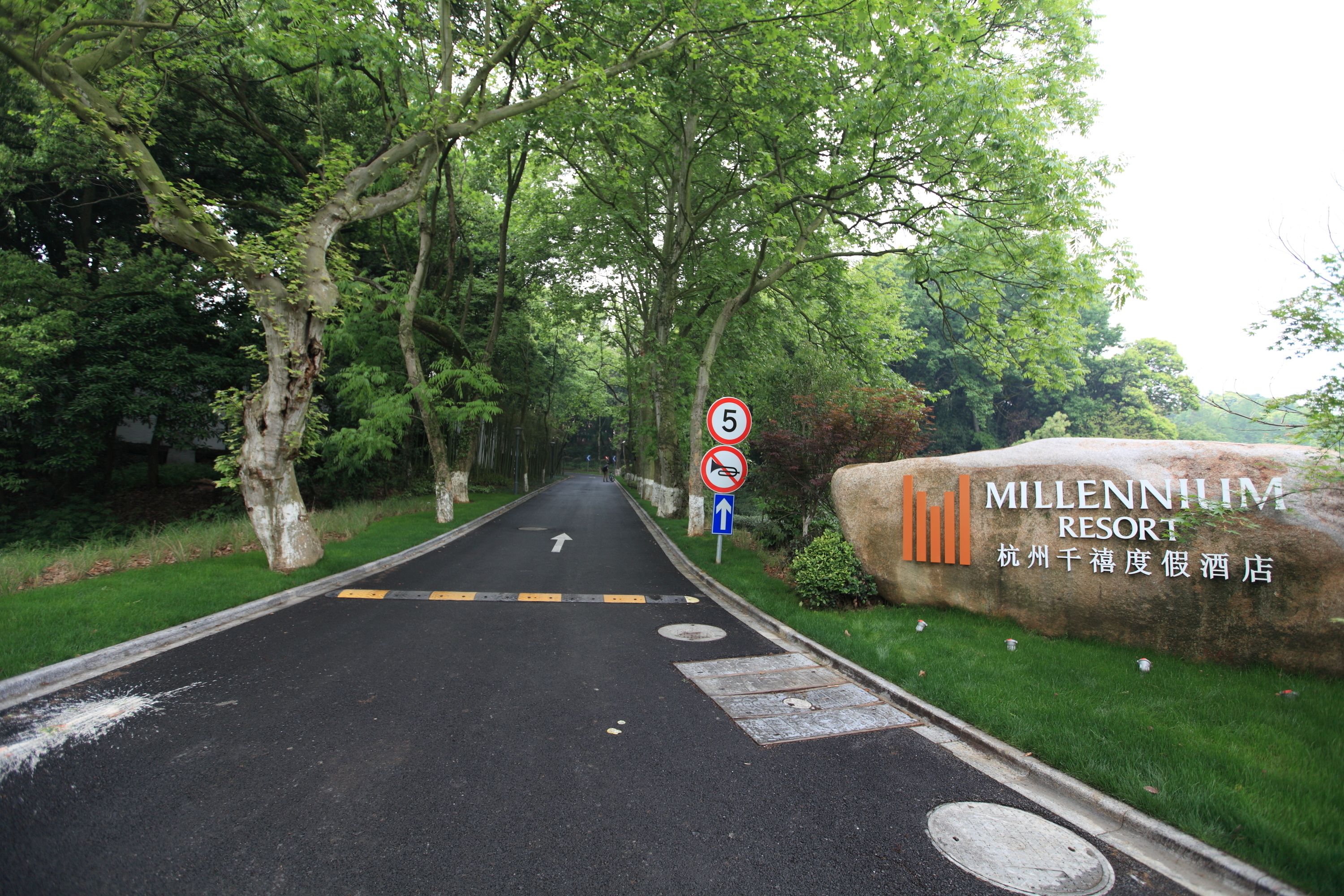 Uma estrada que leva a uma placa do Millennium Resort.