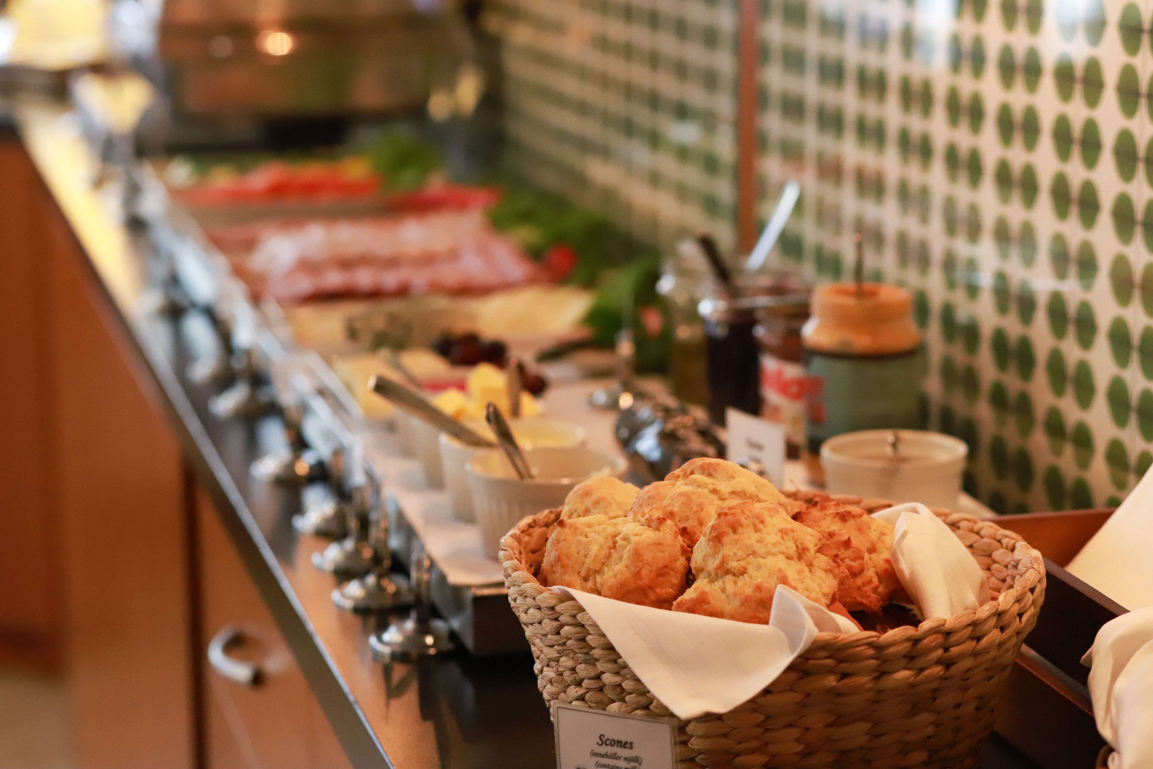 Buffet com diversos alimentos, incluindo scones, molhos e acompanhamentos.