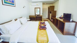 Quarto de hotel com uma cama grande, uma mesa, uma televisão e um banheiro visível por uma porta aberta.