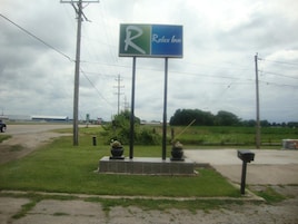 Placa de um Relax Inn com símbolo de estacionamento.