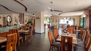 Um restaurante amplo com mobiliário de madeira e um ventilador de teto moderno.