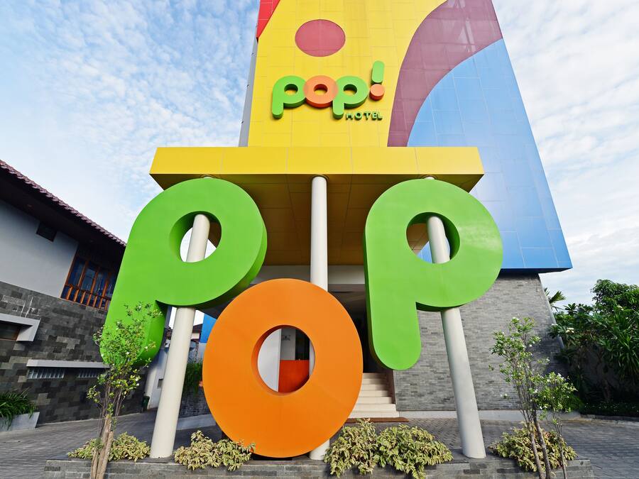 Um letreiro de hotel com letras grandes e coloridas formando a palavra 'POP!' e a palavra 'HOTEL' abaixo.