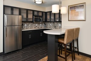 Um frigorífico/congelador grande, um micro-ondas, uma placa de cozinha 