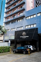 Entrada de hotel com uma placa preta indicando 