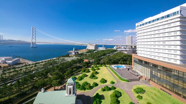 Um hotel com piscina, vista para uma ponte e um jardim paisagístico.