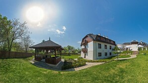 Um imóvel residencial com um gazebo, área de recreação infantil e um gramado bem cuidado.