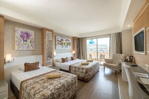 Quarto de hotel com duas camas, uma escrivaninha, uma cadeira e obras de arte nas paredes.