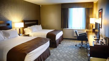 Quarto de hotel com duas camas, uma escrivaninha, uma cadeira, um abajur e uma janela com cortinas.