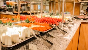 Um buffet com diversos alimentos, incluindo frutas e legumes.