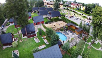 Um bairro residencial com várias casas, uma piscina e um parquinho.
